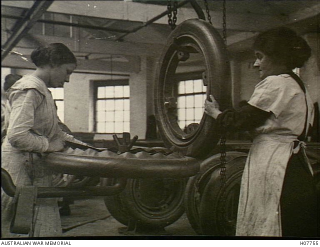Lancashire, England. Two women war workers stripping and hoisting tyres ...
