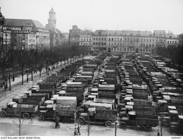 Germany. c. 1918. A German town square full of parked motor lorries ...