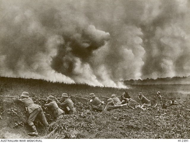 Gas masked German infantry defending from a trench. A messenger dog has ...