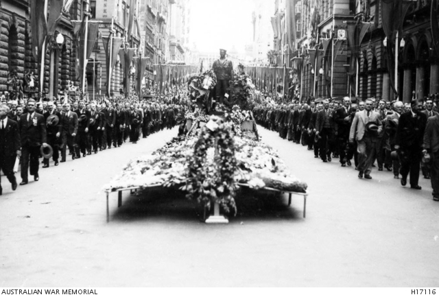 A close view of the Cenotaph and wreath platform and men on both sides ...