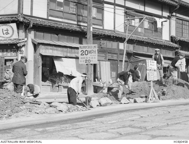 Japanese labourers working on repairing roads and footpaths in a ...
