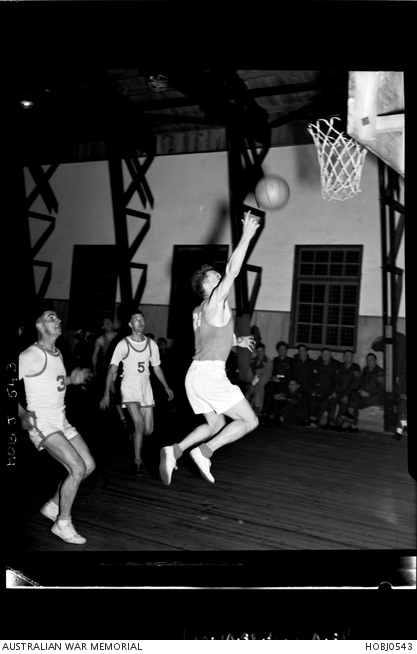 An unidentified basketball player jumps high to shoot for a goal, after ...