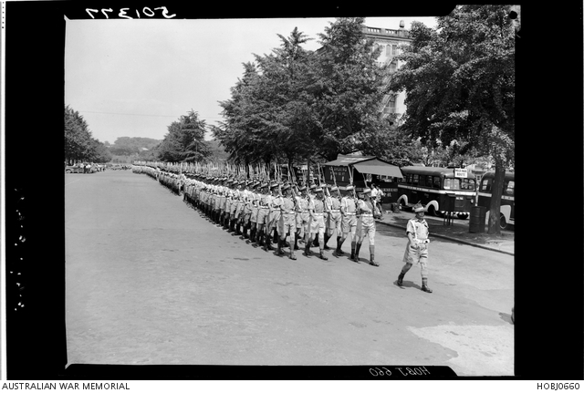 A troop of Australian Army servicemen march with rifles at the slope ...