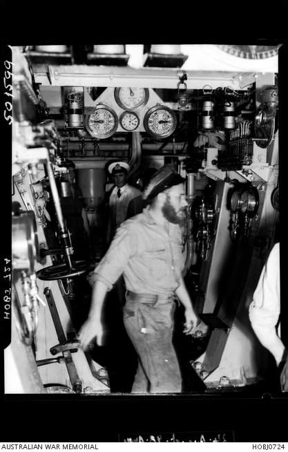 Unidentified engine-room crew, possibly on HMAS Shoalhaven, attend to ...