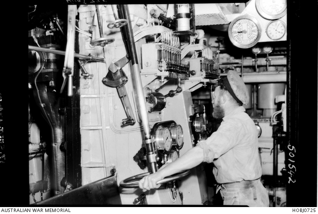 An unidentified engine-room crew member, wearing a beard and moustache ...