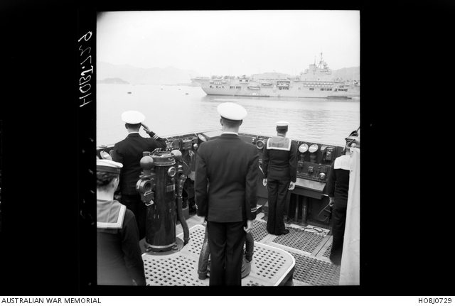 An RAN Commander (Cdr)(left), possibly Cdr I H McDonald, salutes an ...