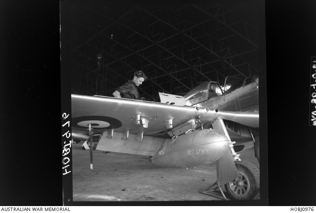 An unidentified armourer from 77 Squadron RAAF, loads ammunition into ...
