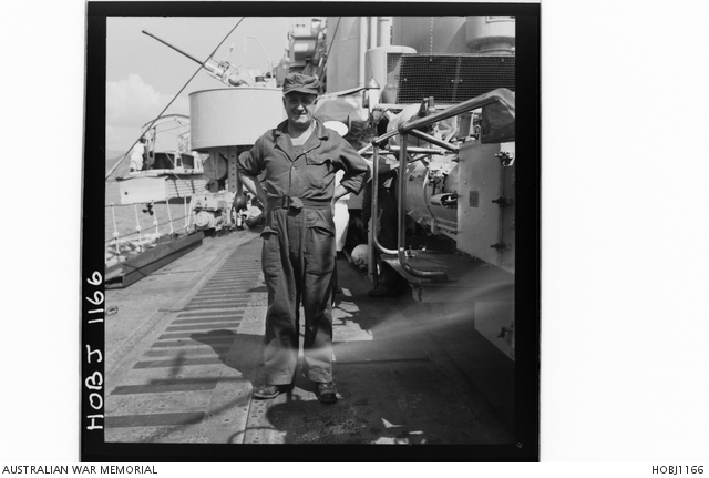An unidentified sailor wearing overalls on the deck of HMAS Bataan. The ...