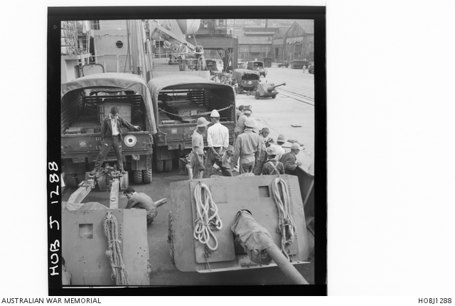 Japanese wharf labourers work on securing military trucks and 17 ...