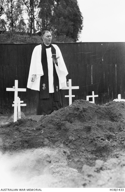 Wearing a surplice and cassock, 240103 Padre A W Laing conducts a ...