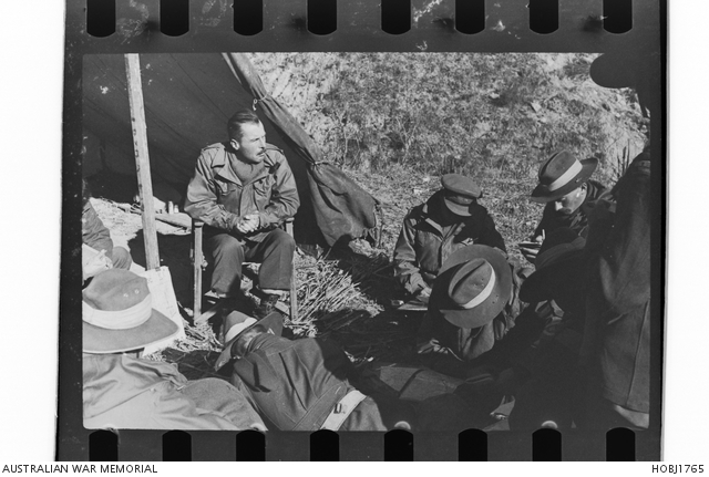 Lieutenant Colonel (Lt Col) I B Ferguson sits at the front of his tent ...