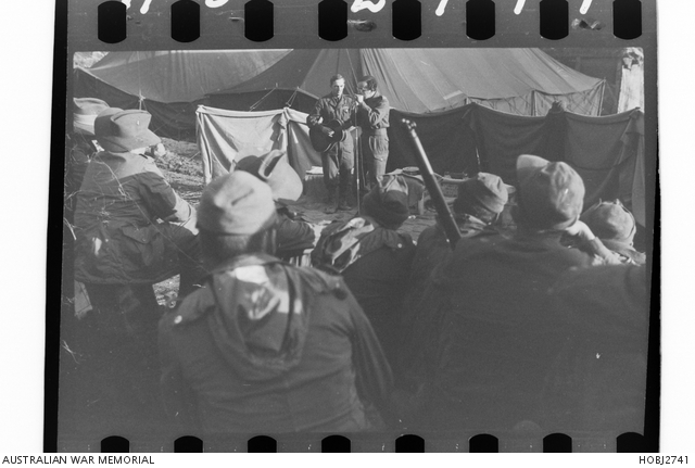 Larry Adler (right) performs for troops on an impromptu stage in a camp ...
