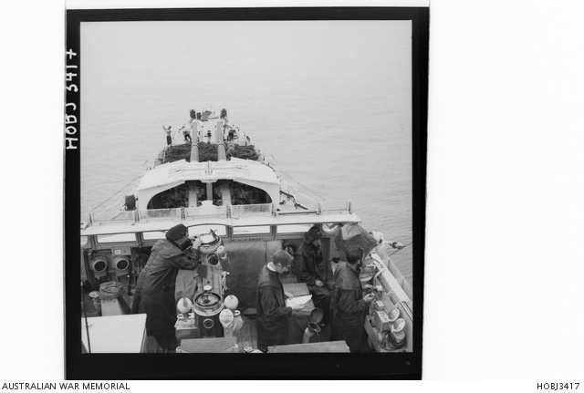Four unidentified crew members attend to tasks on the bridge of HMAS ...