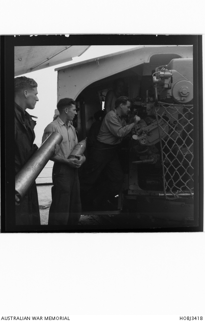 Crew members carry out a drill on a 4.7 inch Mk XIX mounting on the ...