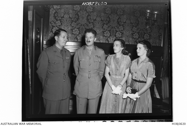 An informal portrait of two unidentified officers and two civilian ...