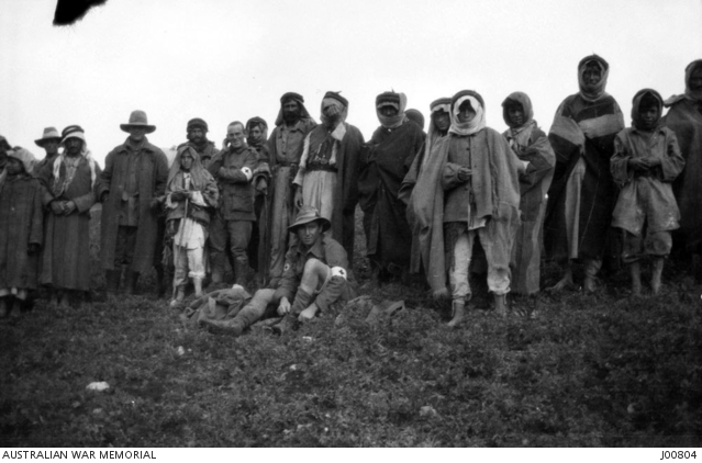 Group of local men and boys with four unidentified Australian field ...