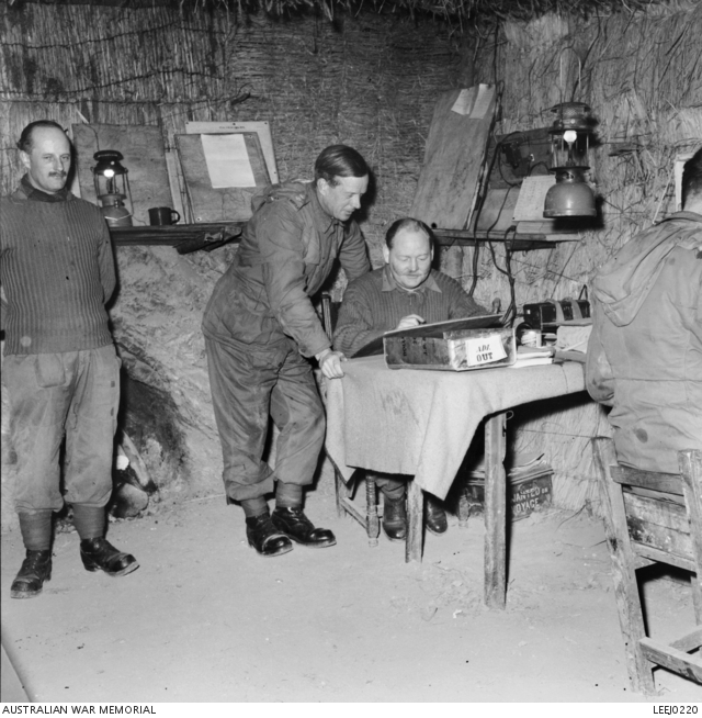 Senior officers work in a a Command Post dugout in a camp or ...