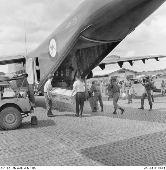 American servicemen and South Vietnamese troops help load an RAAF ...