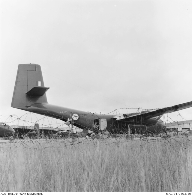 One of the RAAF Caribou seen through the barbed wire barricades near ...