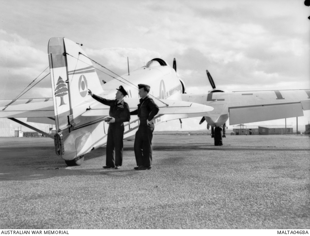 Pilot Officer Keith Meggs DFM of Preston, Vic points out features of a ...