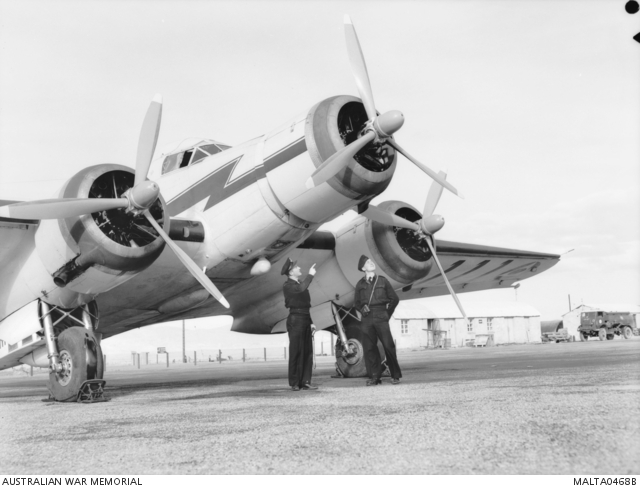 Pilot Officer Keith Meggs DFM of Preston, Vic points out features of a ...