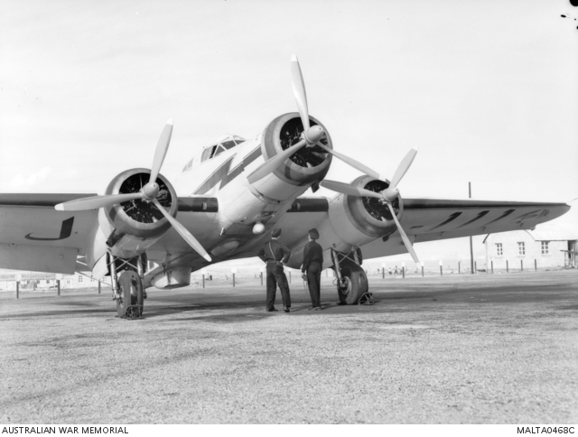 Pilot Officer Keith Meggs DFM of Preston, Vic points out features of a ...