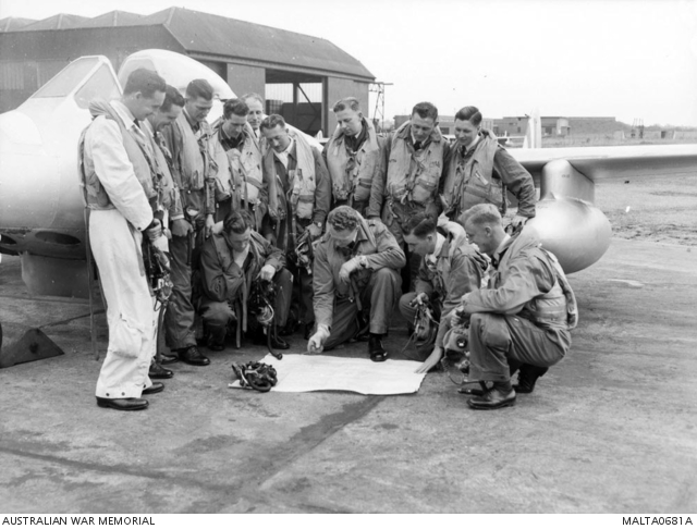 Pilots from 78 Fighter Wing RAAF look at a map of their route on the ...