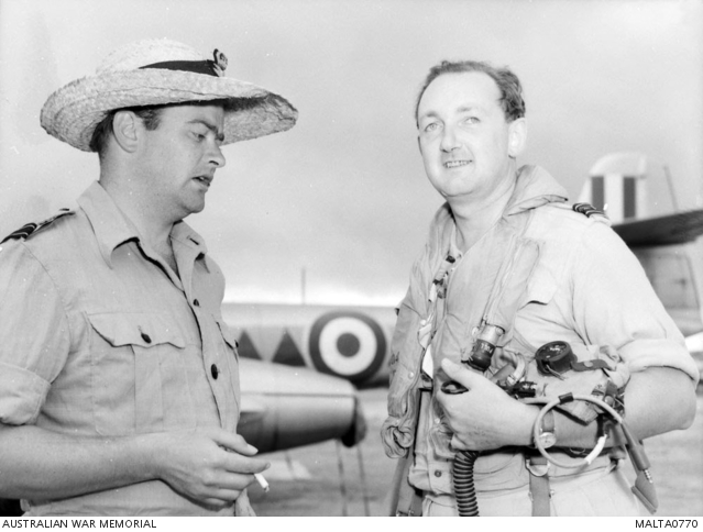 Flight Lieutenant (Flt Lt) Derek Dempster (wearing straw hat) chats ...