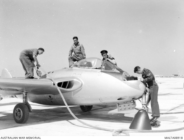 Australian and New Zealand servicing crew work on a Vampire fighter ...
