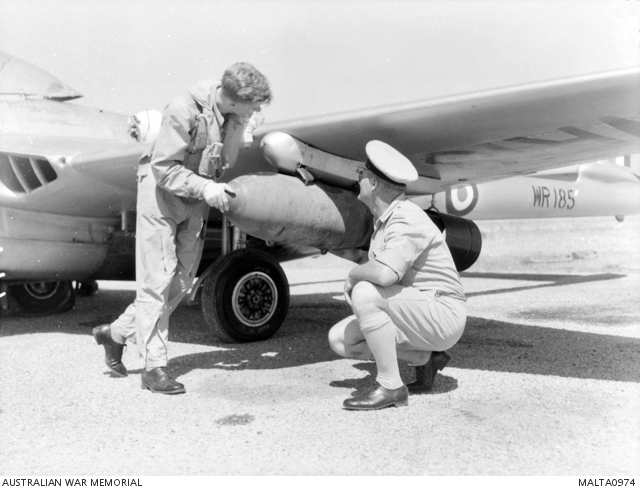Pilot Officer Jake Newham of Cowra, NSW (left), checks the bombs that ...