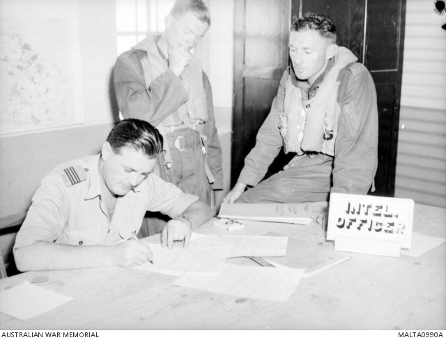 Two RAAF pilots talk to their Debriefing Officer after returning from ...