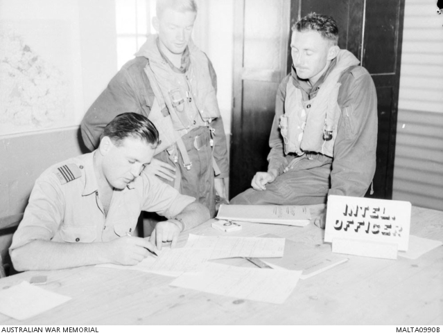 Two RAAF pilots talk to their Debriefing Officer after returning from ...