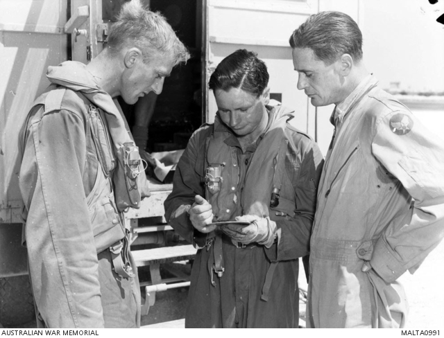 The Flight Commander of 75 Squadron RAAF checks flight plans with two ...