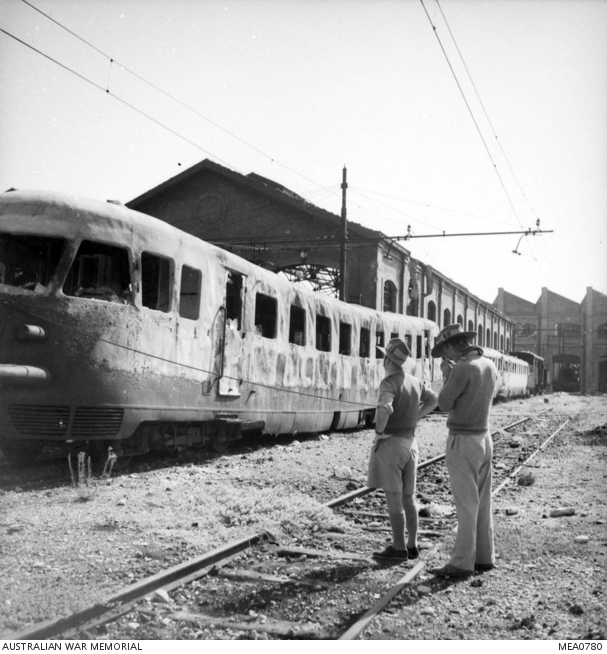 Italy. c. September 1943. RAAF members examine a wrecked diesel train ...
