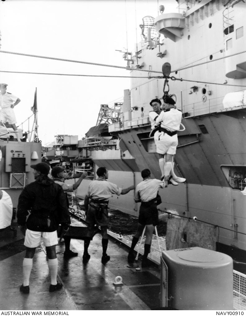 Two unidentified naval officers in a jackstay transfer between the ...
