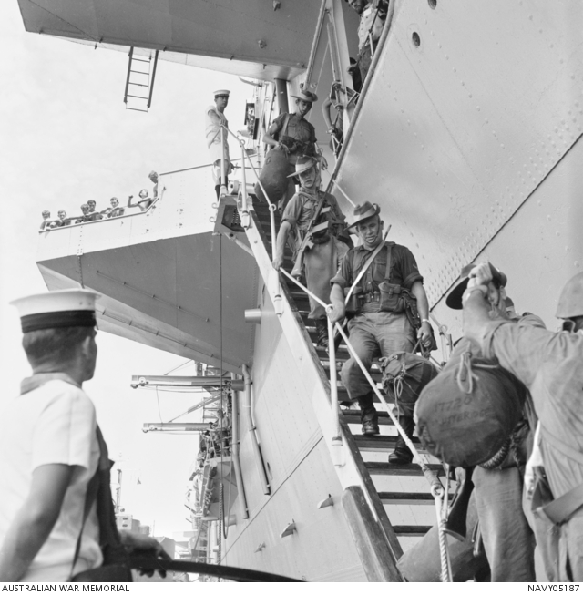 Australian soldiers disembark down a gangway from the troop transport ...