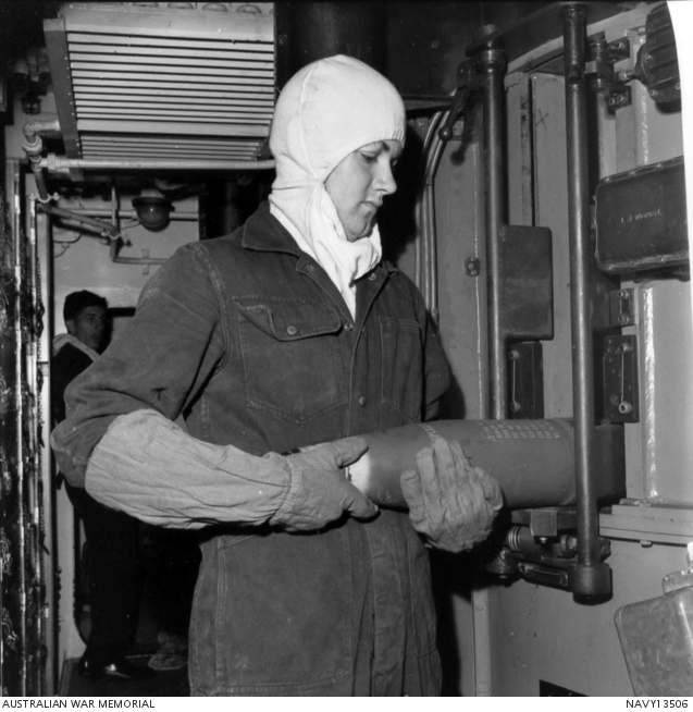 Cook R N Wickham, R62324 loads a five-inch shell into B drum in the aft ...