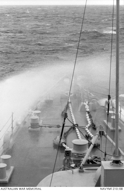 A rough sea breaks over the bow of the RAN guided missile destroyer ...