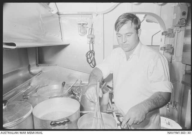 Cook in the galley of HMAS Vampire. | Australian War Memorial