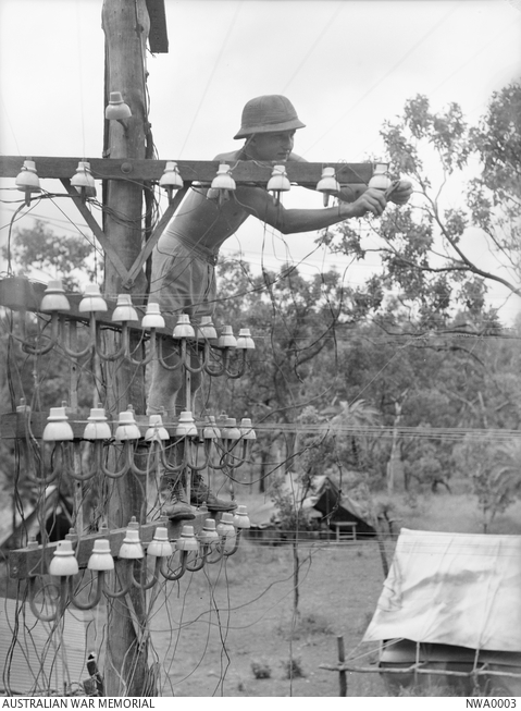 Probably Batchelor, NT. 20 January 1943. A linesman high up on a ...