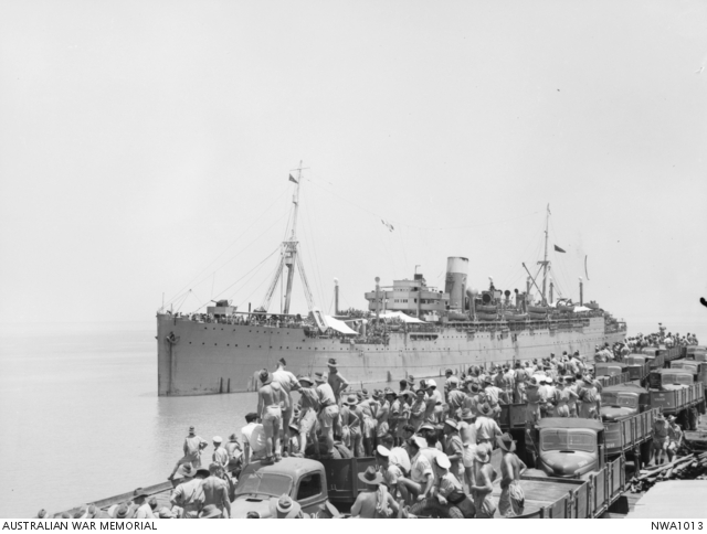 Darwin, NT. 1945-09. A large crowd watches from the wharf as the ship ...