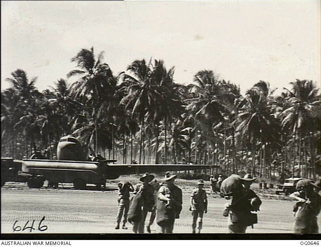 PAPUA-NEW GUINEA AREA. 1944-02-04. RAAF PERSONNEL WALKING ACROSS AN ...