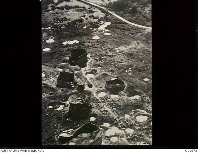 TARAKAN ISLAND, BORNEO. C. 1945-05. AERIAL PHOTOGRAPH OF BOMB CRATERS ...