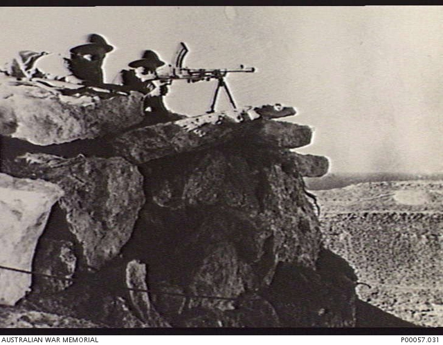 SIDI BARRANI, EGYPT. 1941. TWO GUNNERS SURVEY THE AREA FROM A VANTAGE ...