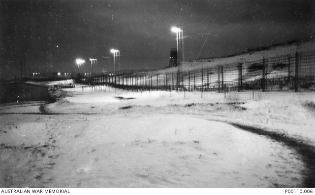 "STALAG 383 AND THE SECURITY WIRES AND LIGHTS AT NIGHT. THE SENTRY BOX ...