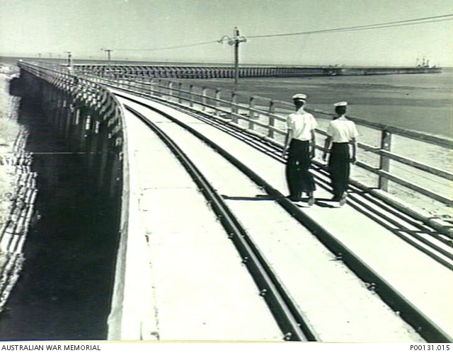 ONSLOW, WESTERN AUSTRALIA. TWO SAILORS WALKING ALONG THE JETTY WHICH ...