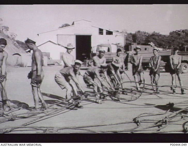 Royal Australian Naval ratings man handling the steel cable on a ...