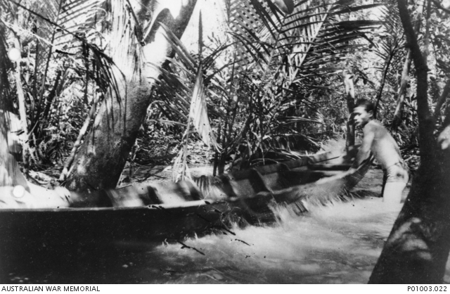 A Viet Cong (VC) swimmer sapper prepares to board a small boat on a ...