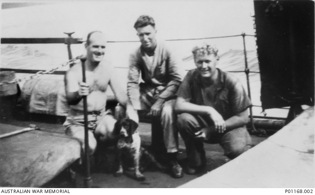 At sea, 1943-10-06. Three members of the crew of HMAS Wagga on the deck ...