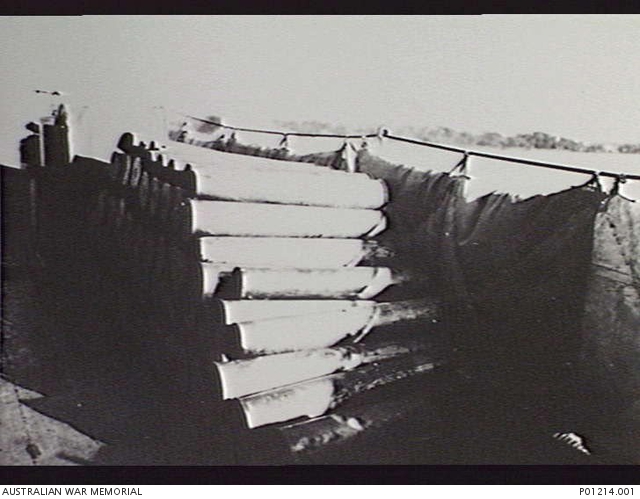 1942-02-19. DARWIN, NT. 4 INCH SHELL CASINGS STACKED AGAINST THE RAIL ...